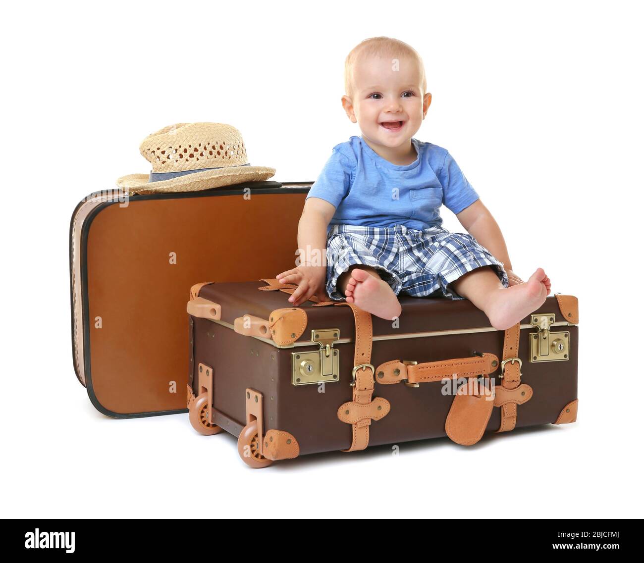 Baby sitting on suitcase on white background Stock Photo - Alamy
