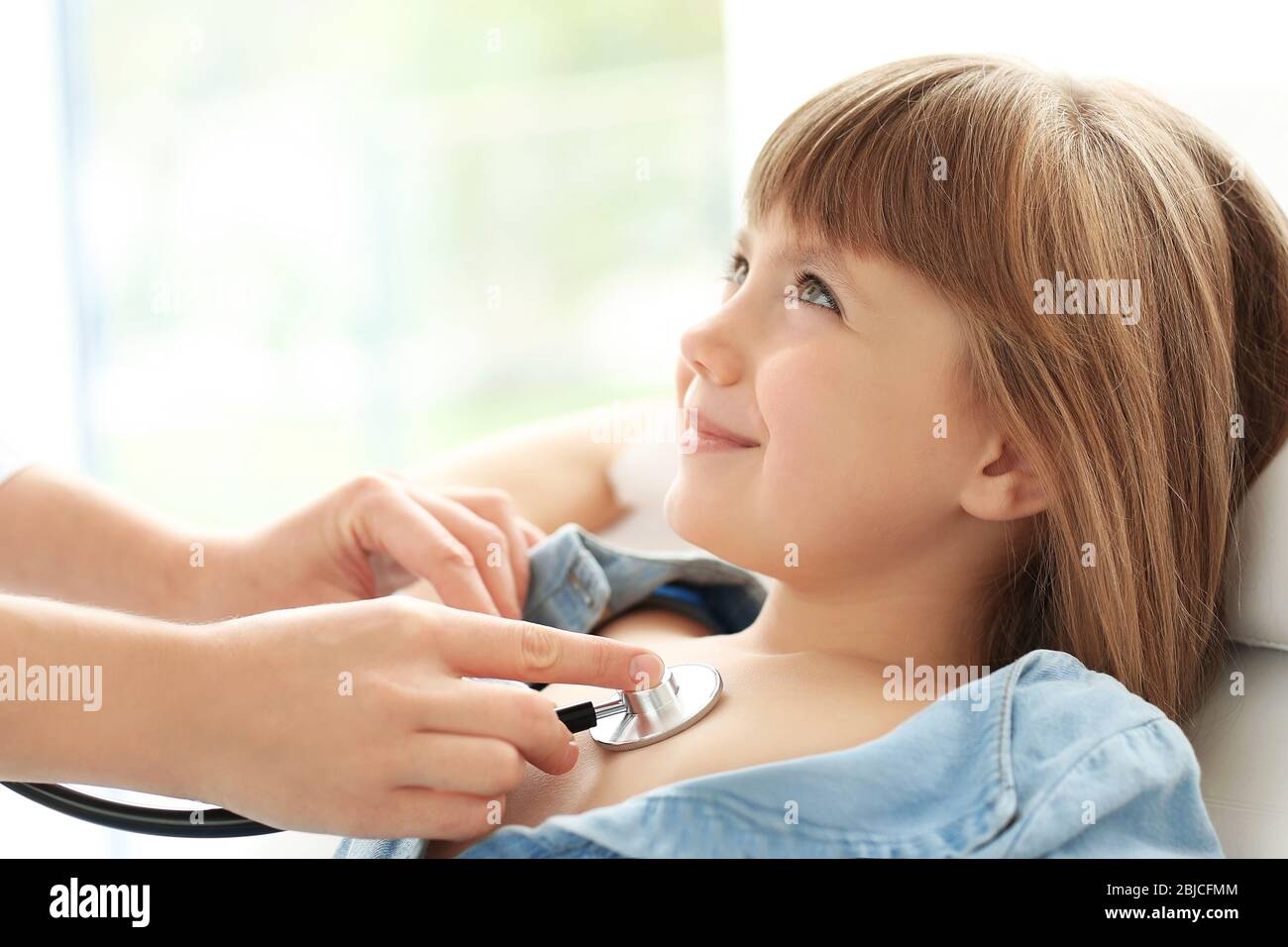Pediatrician examining little girl's heart Stock Photo - Alamy