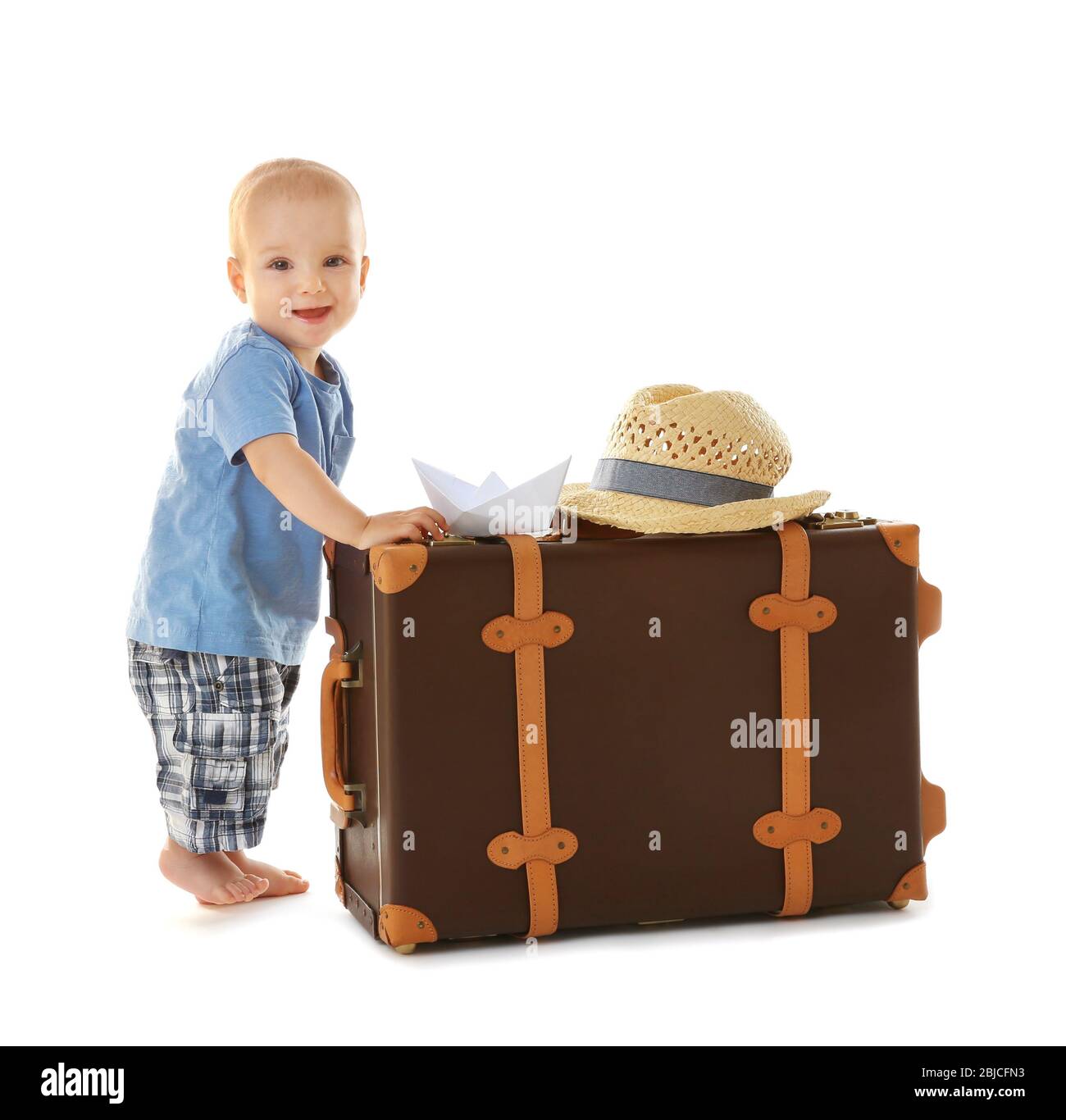 Baby standing with suitcase on white background Stock Photo - Alamy