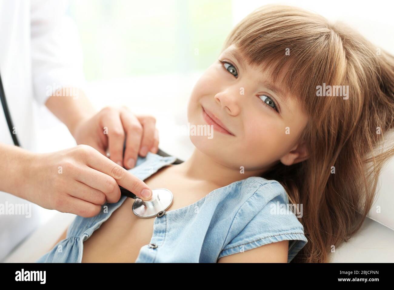 Pediatrician examining little girl's heart Stock Photo - Alamy
