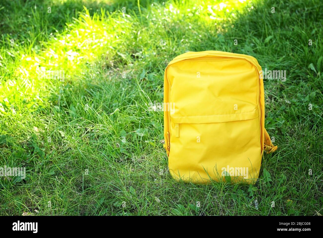 Yellow rucksack on green grass Stock Photo - Alamy