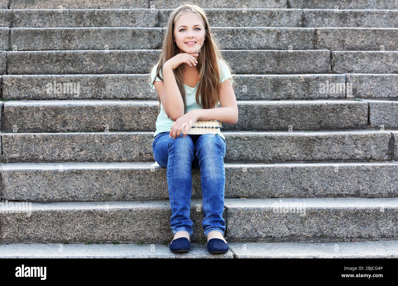 Pretty teenager girl sitting on stairs outdoors Stock Photo - Alamy