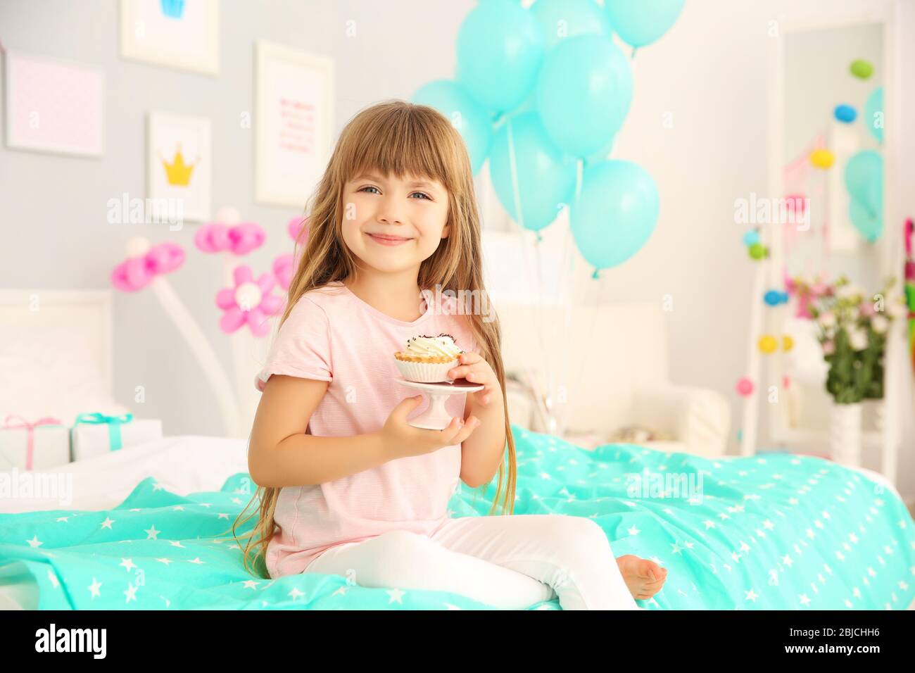 Cute birthday girl sitting on bed with tasty cake Stock Photo - Alamy