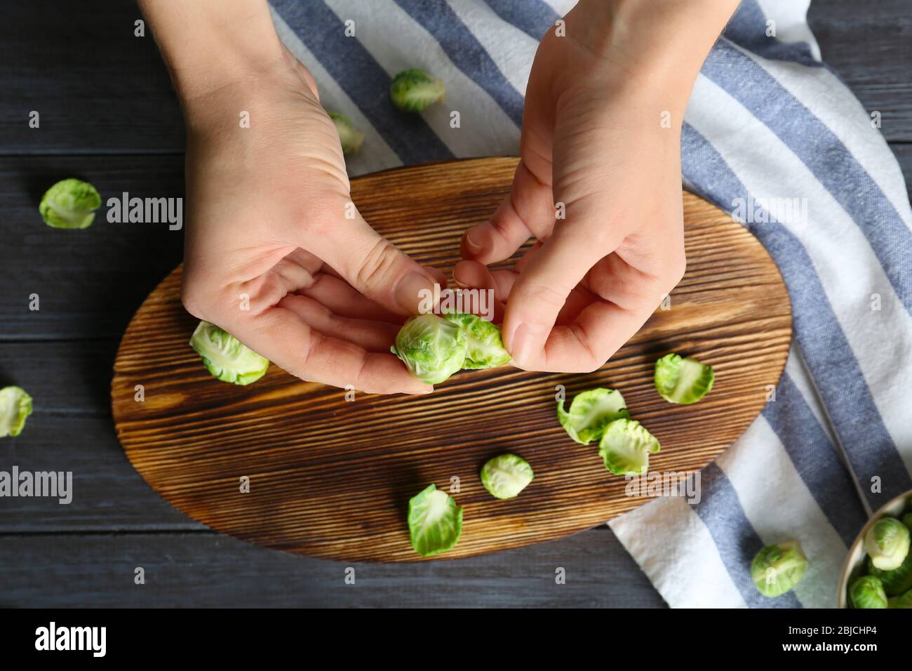 Female hands peeling Brussels sprouts on wooden board Stock Photo - Alamy