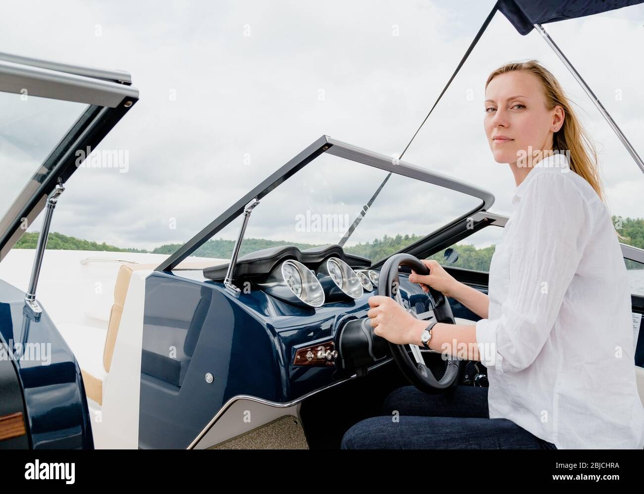 Young woman driving a motorboat Stock Photo - Alamy