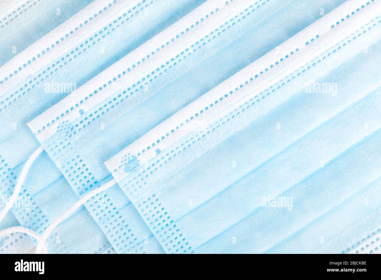 Lots of simple blue protective face masks background texture. Many one ...
