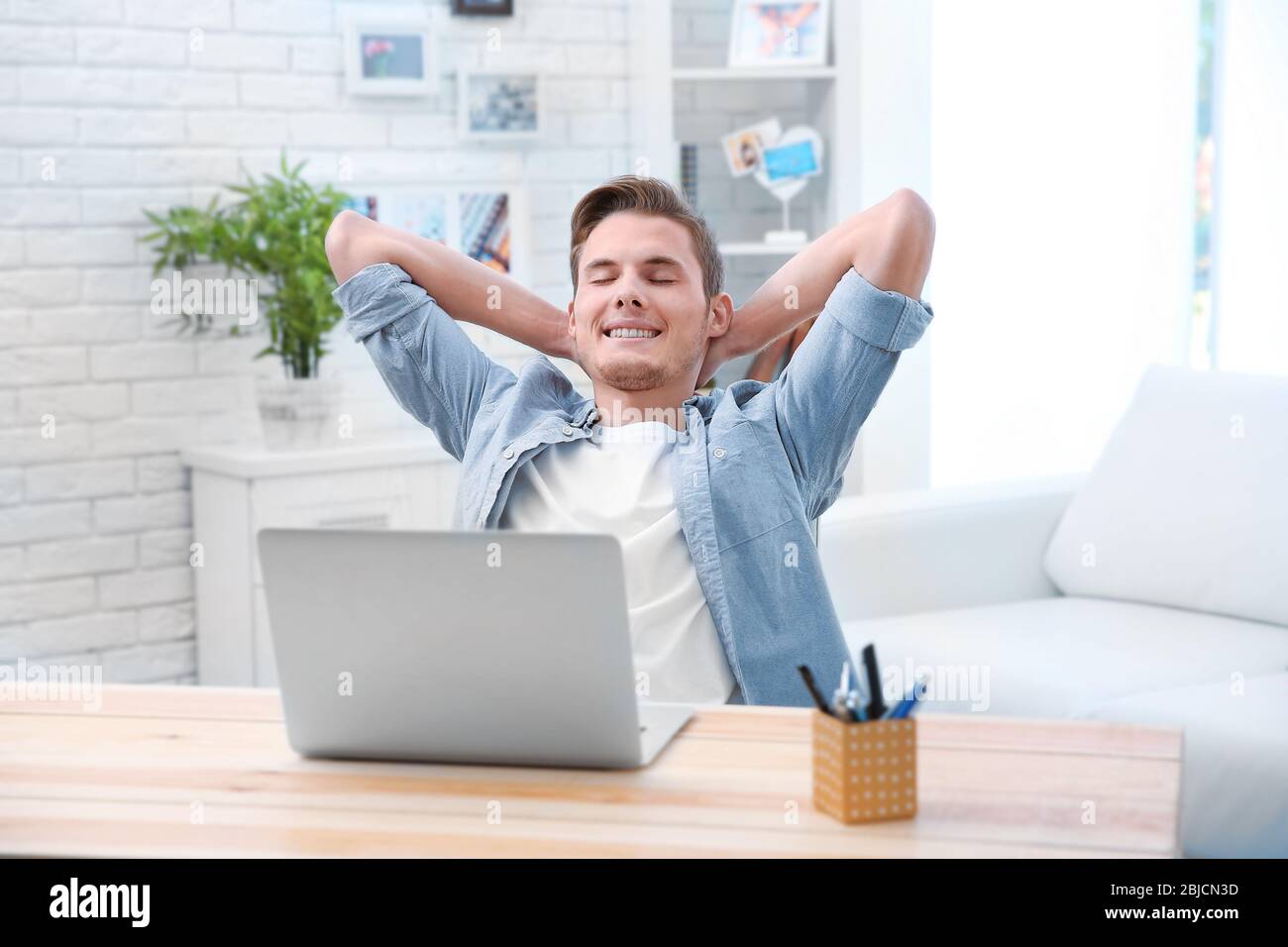 Handsome man relaxing in office Stock Photo - Alamy