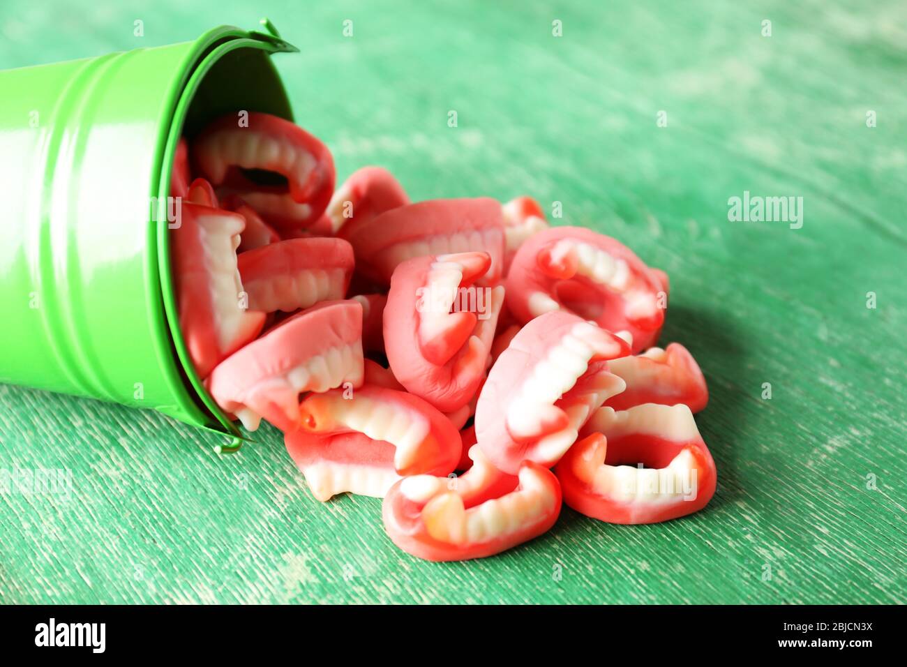 Heap of assorted jelly sweets in bucket on wooden background Stock ...