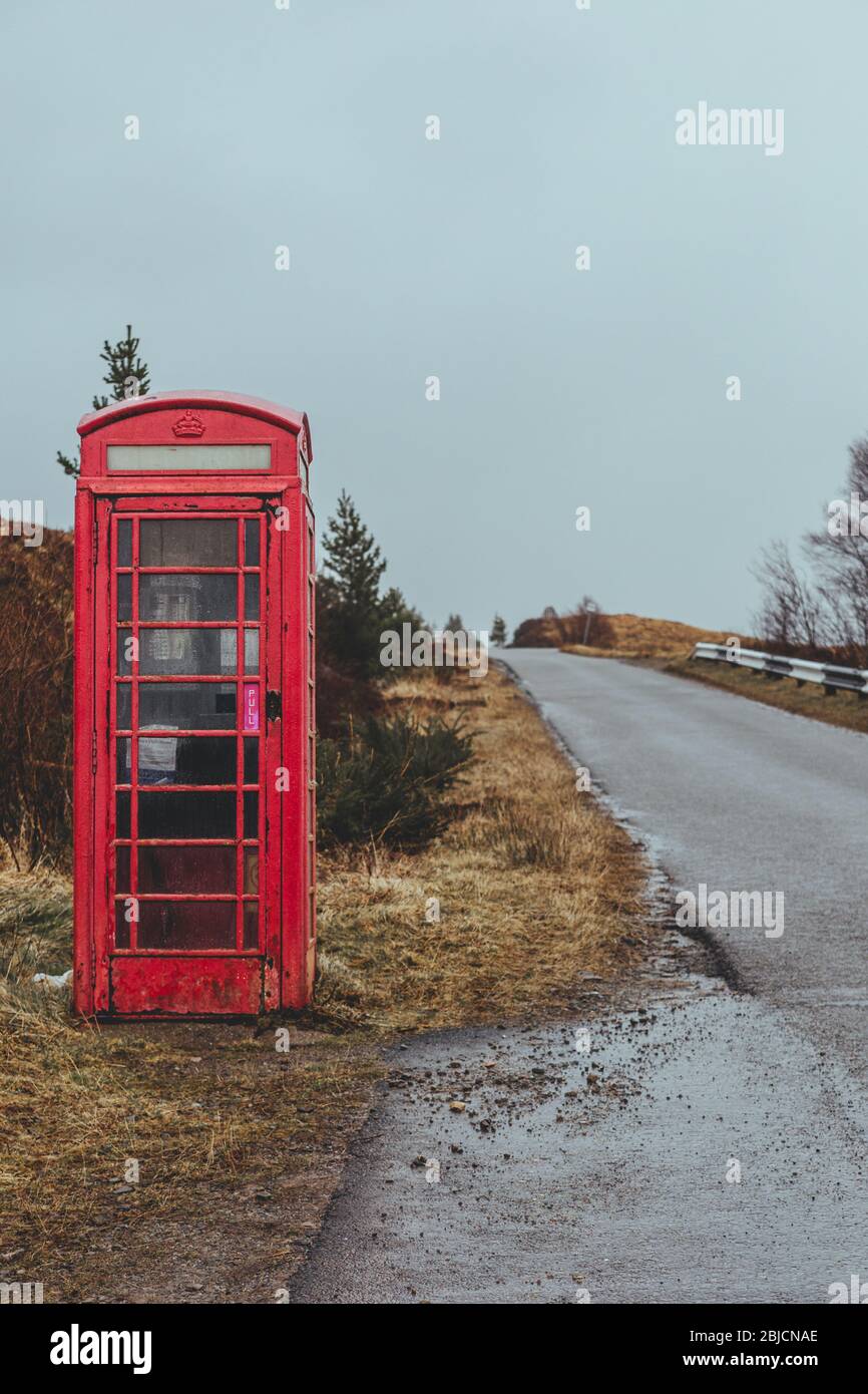 Traditional red telephone box on a side of a road in the Scottish ...