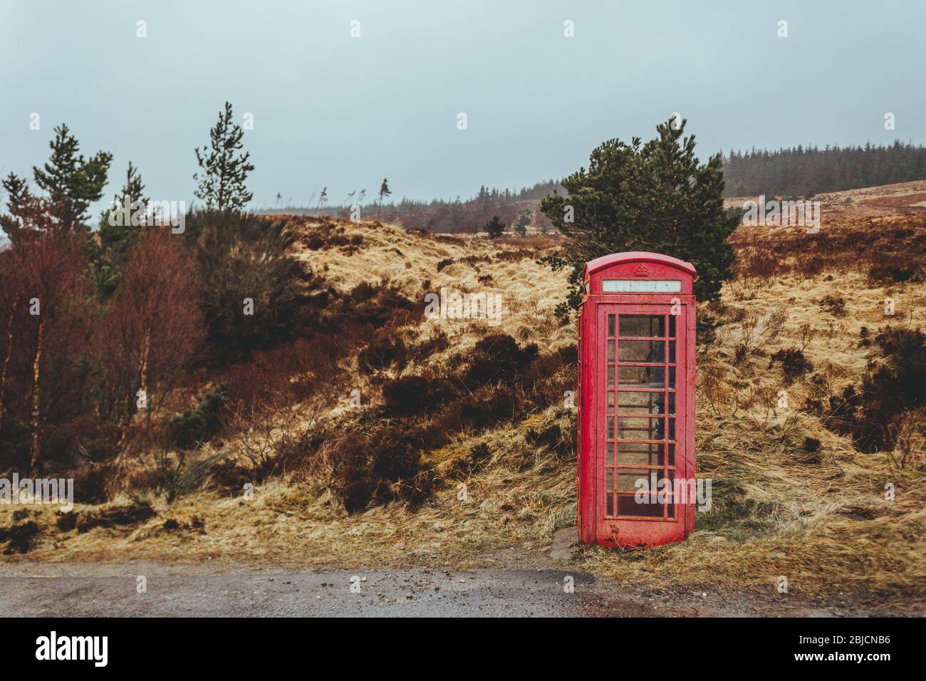 Traditional red telephone box on a side of a road in the Scottish ...