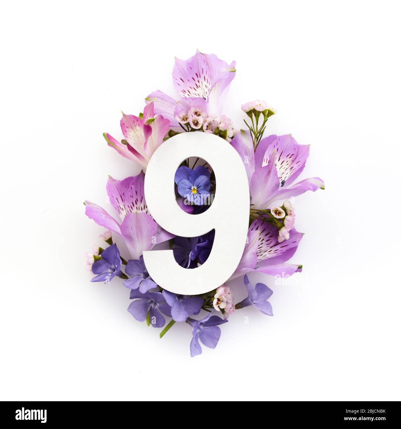 Creative layout with colourful flowers and number nine. Flat lay. Top ...