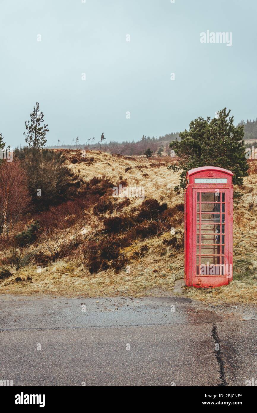 Traditional red telephone box on a side of a road in the Scottish ...