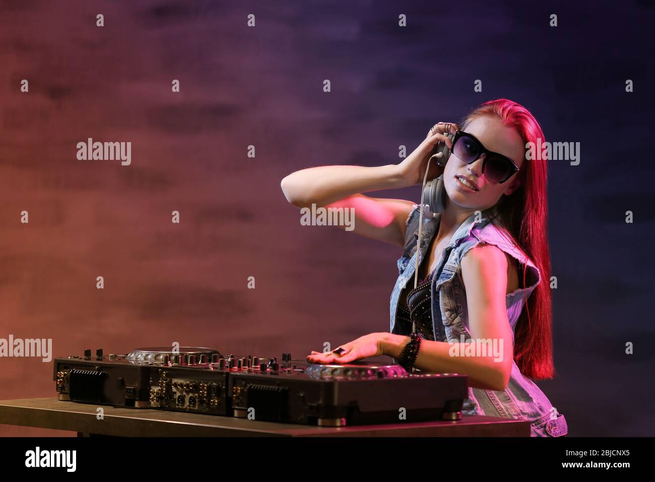 DJ mixing music on color background Stock Photo - Alamy