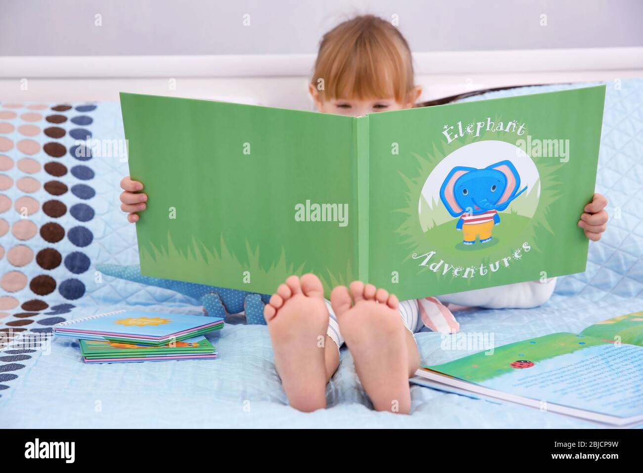 Little cute girl reading book Stock Photo - Alamy