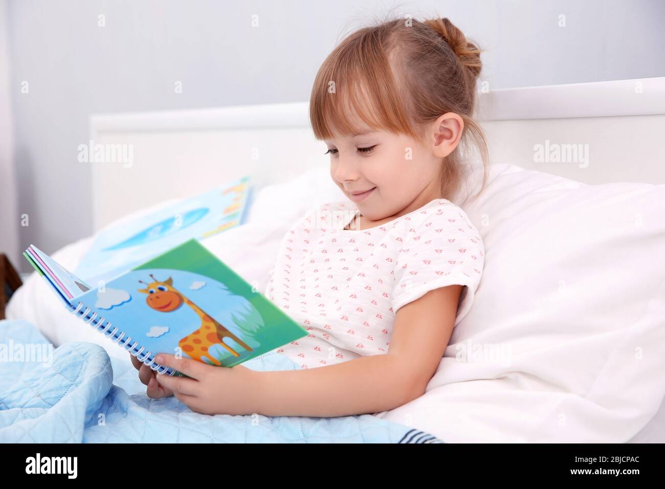 Little cute girl reading book Stock Photo - Alamy