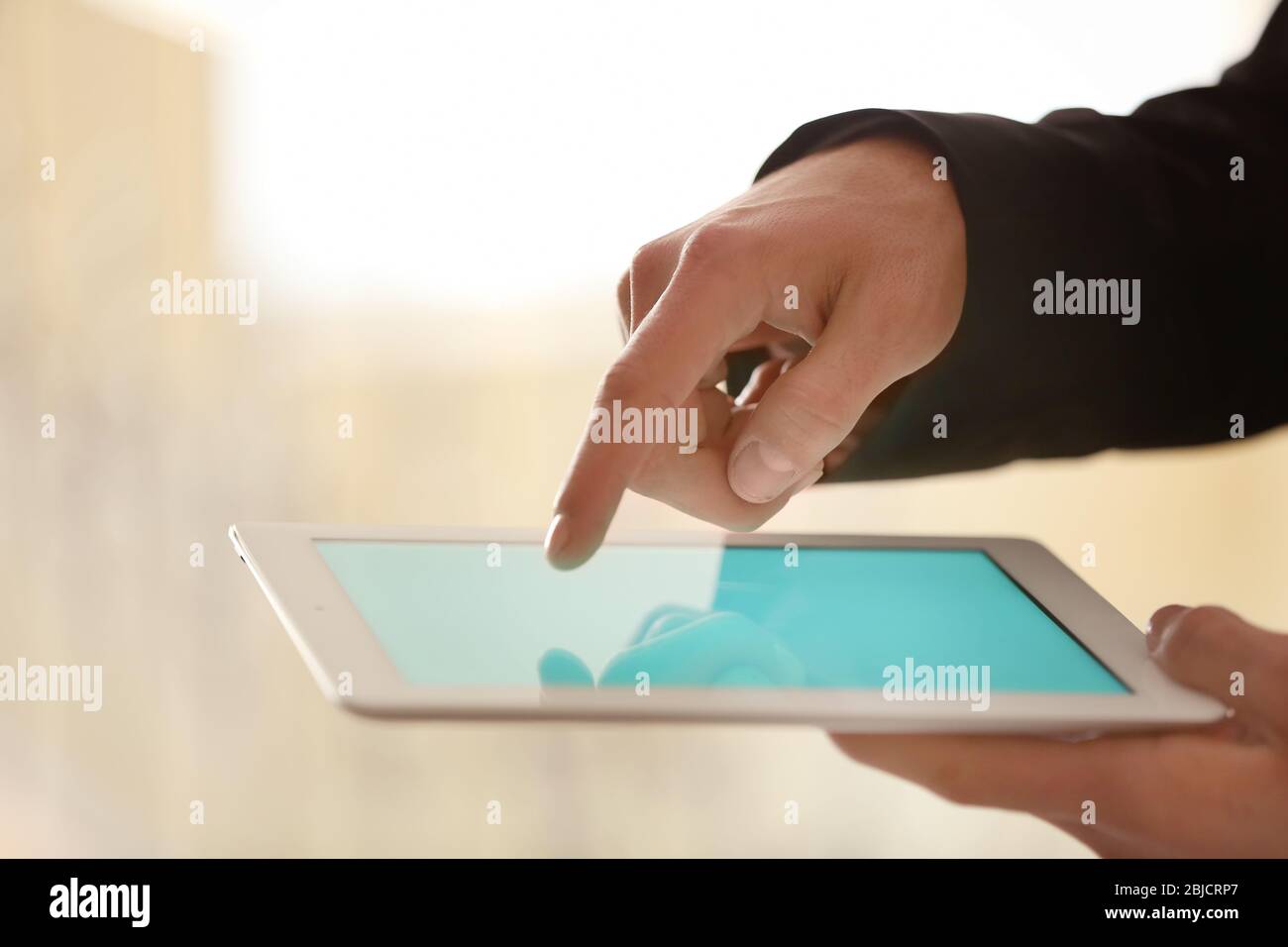 Male finger touching tablet screen on blurred background Stock Photo ...