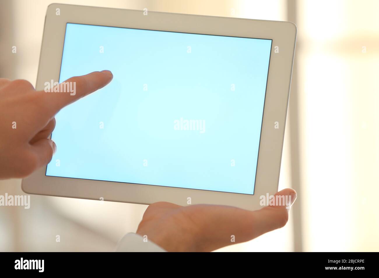 Male finger touching tablet screen on blurred background Stock Photo ...