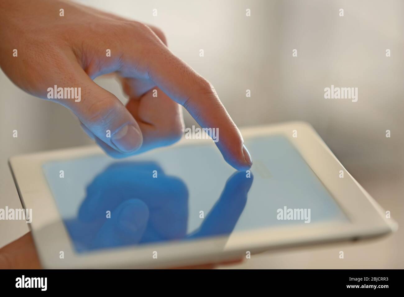 Male finger touching tablet screen on blurred background Stock Photo ...