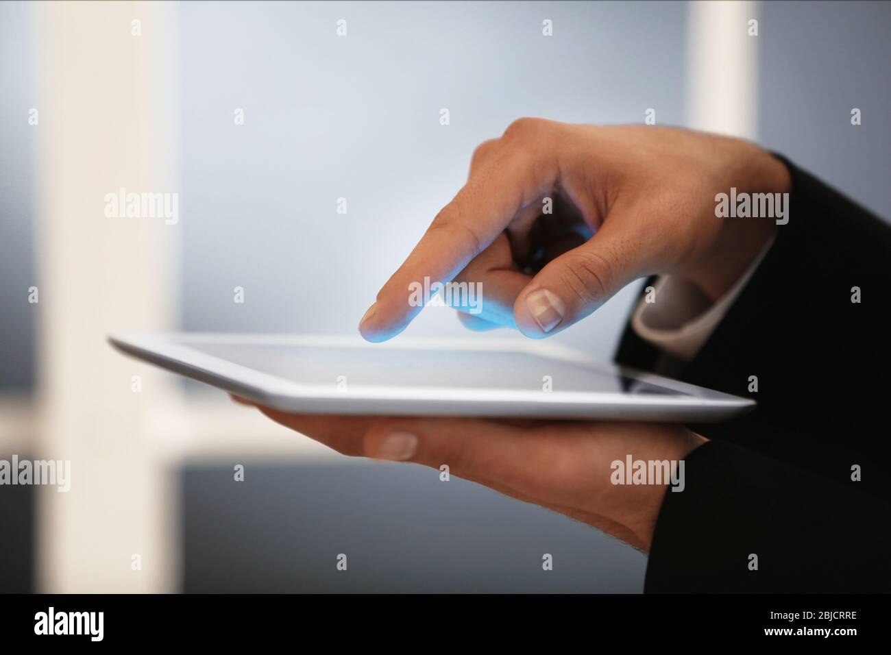 Male finger touching tablet screen on blurred background Stock Photo ...