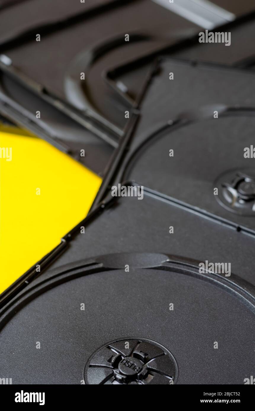 Group of empty DVD boxes on a yellow background. Black plastic boxes ...