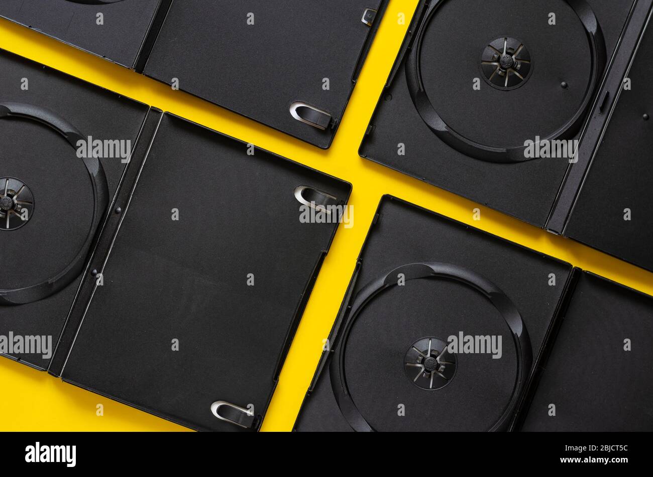 Open Empty DVD Boxes On A Yellow Background. Four plastic boxes for ...