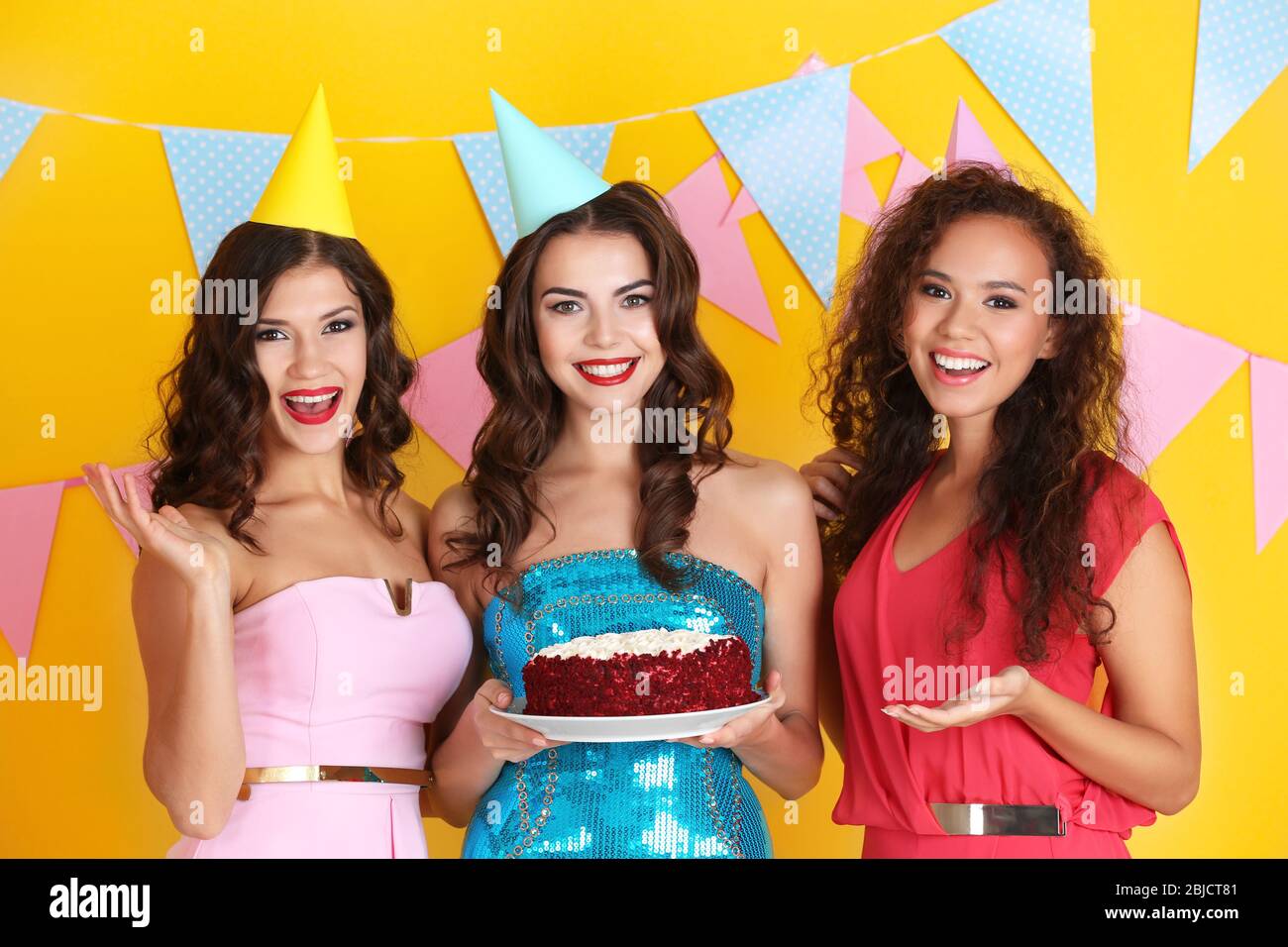 Beautiful young women at birthday party on yellow background Stock ...