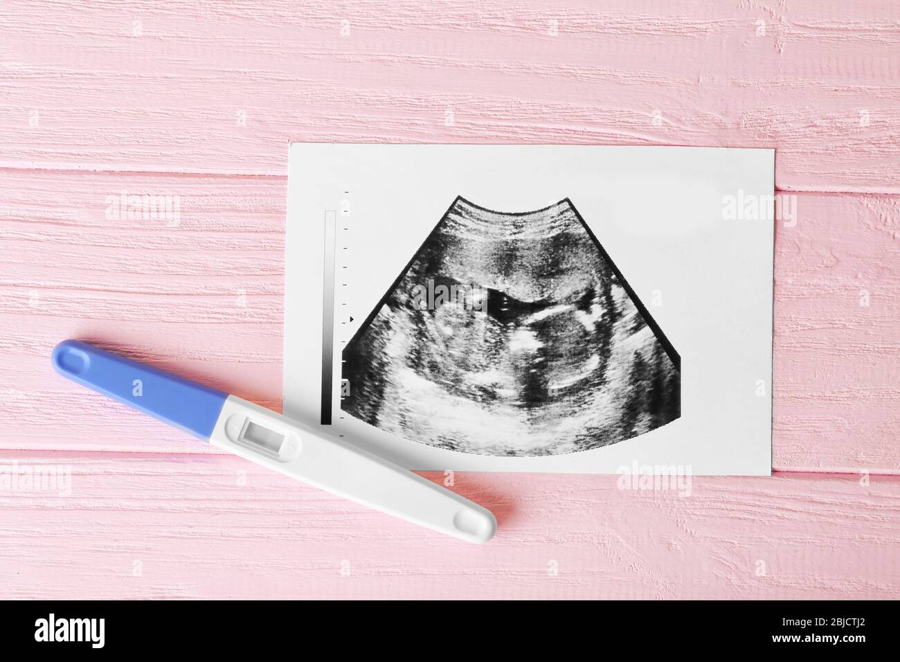 Ultrasound photo and pregnancy test on pink wooden background Stock ...
