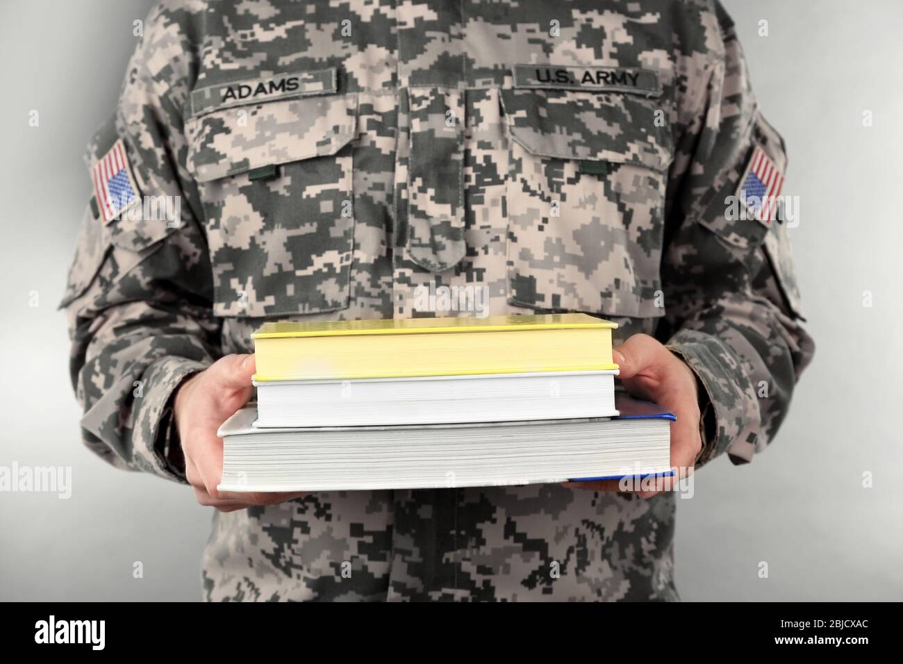 Soldier holding books. Military education concept Stock Photo - Alamy