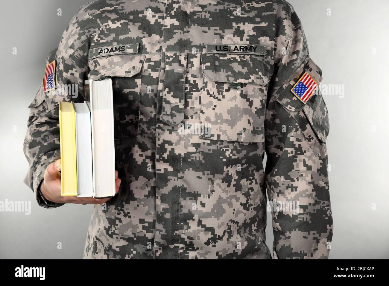 Soldier holding books. Military education concept Stock Photo - Alamy