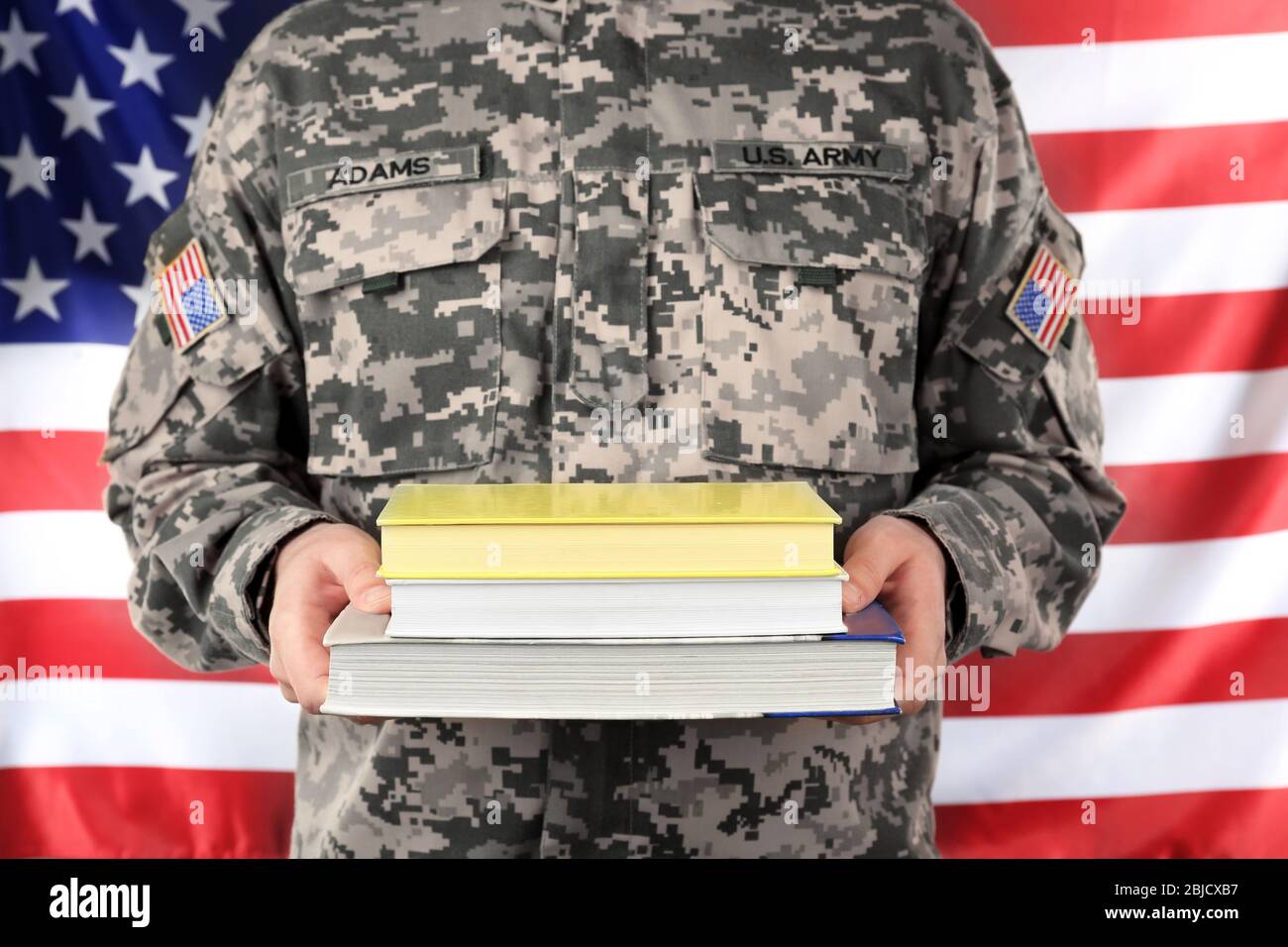 Soldier holding books. Military education concept Stock Photo - Alamy