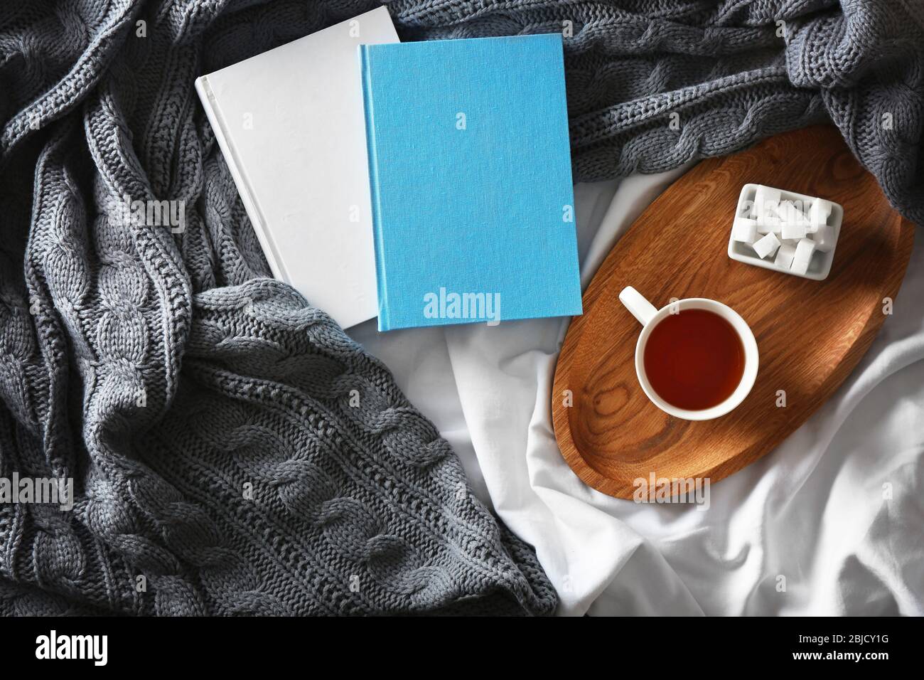 Books with cup of tea on bed Stock Photo - Alamy