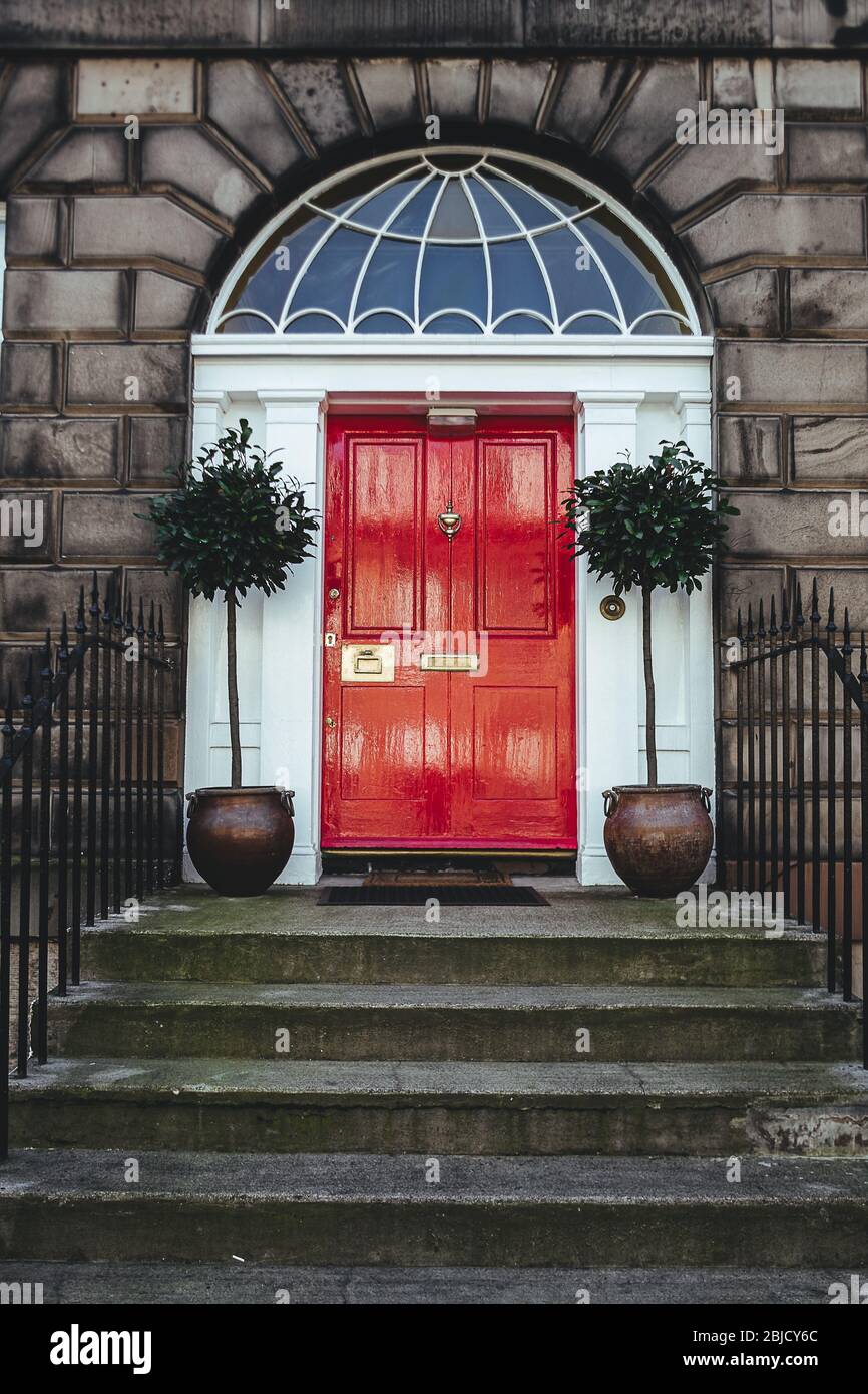 Colorful red entrance door on a facade of a traditional house in ...