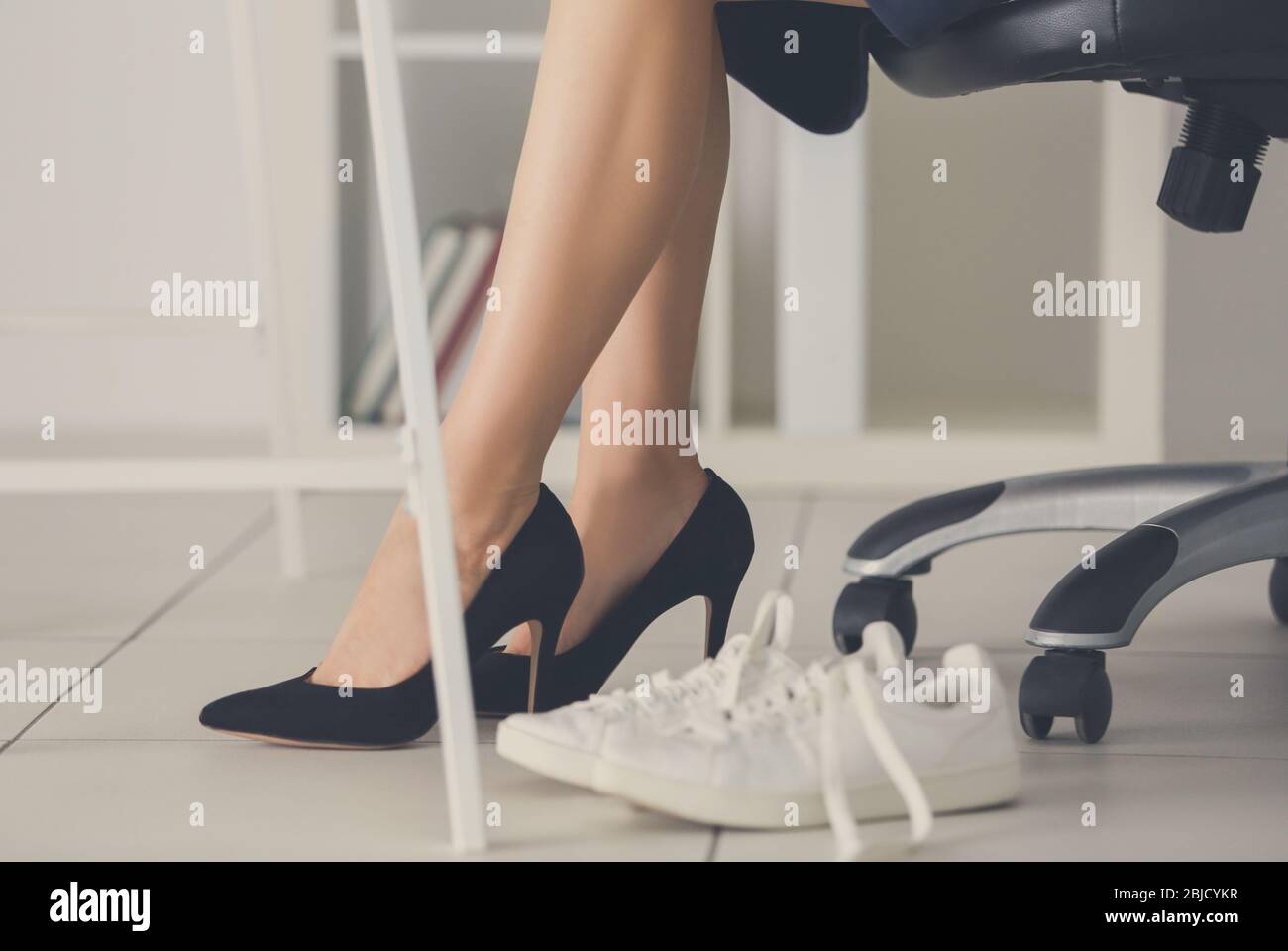 Woman changing shoes in office at work Stock Photo - Alamy