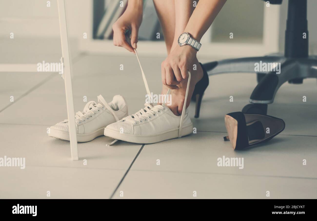 Woman changing shoes in office at work Stock Photo - Alamy