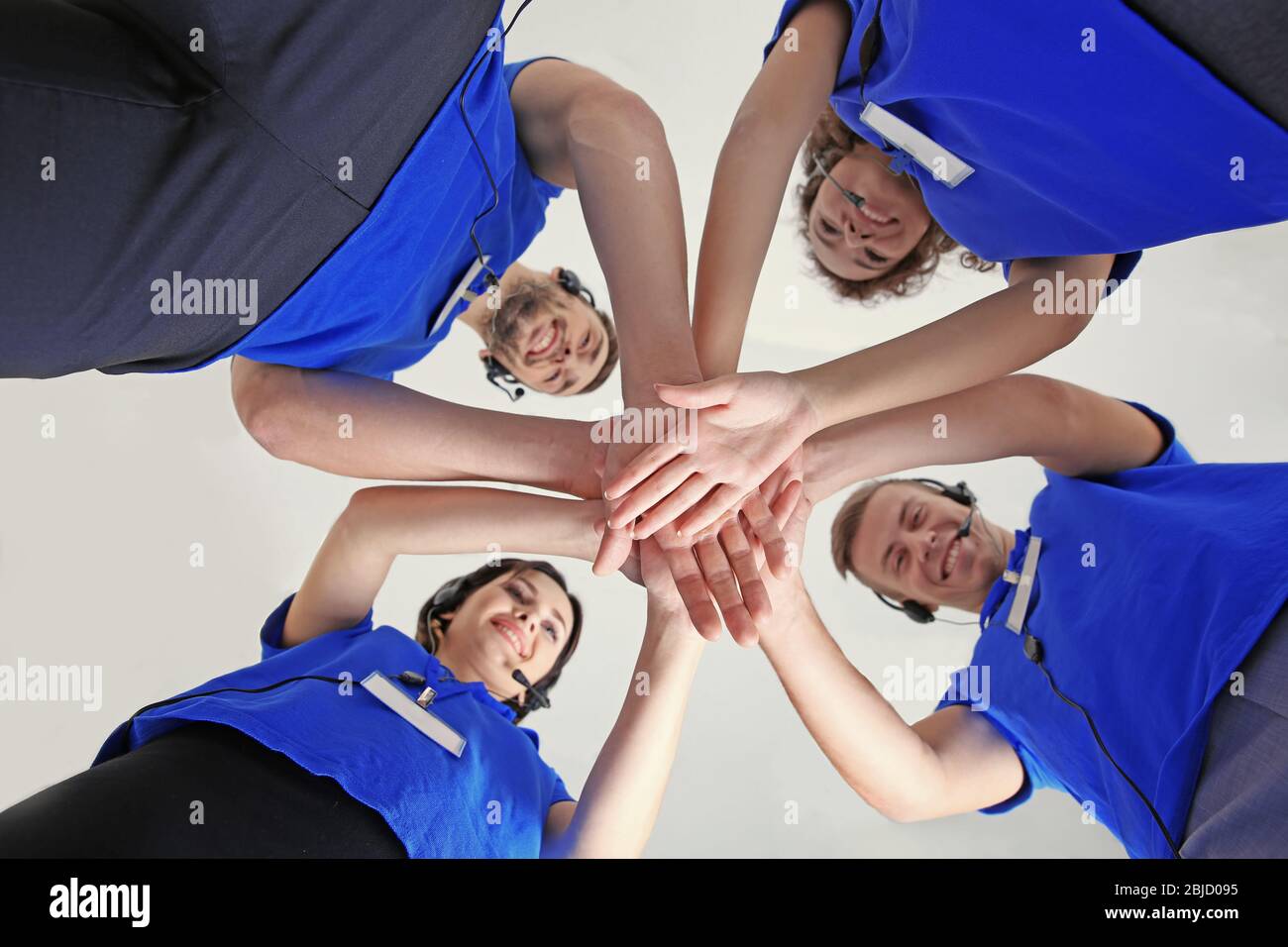 Team of technical support dispatchers holding hands together Stock ...
