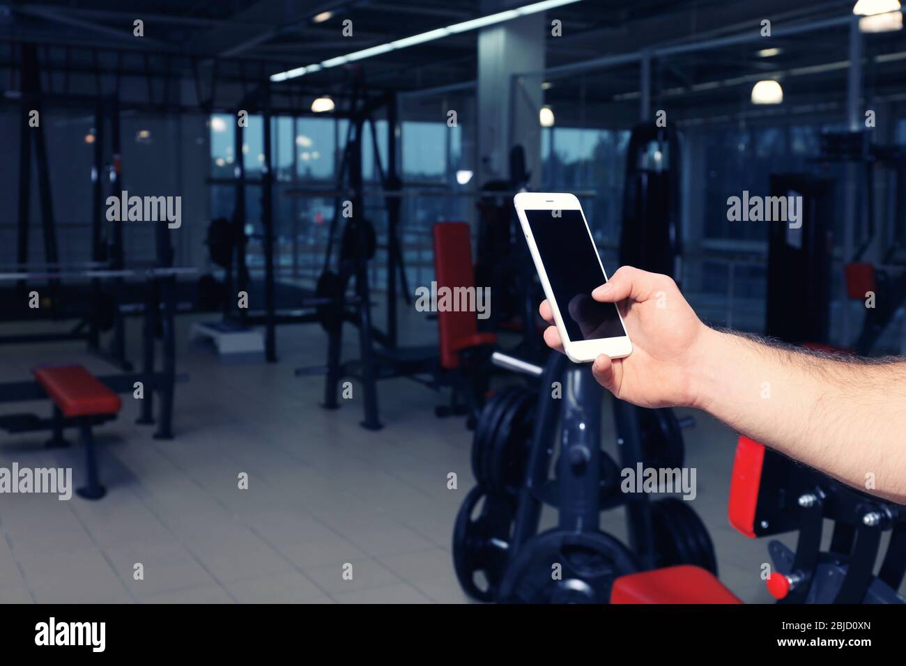 Male hand with modern phone in gym Stock Photo - Alamy