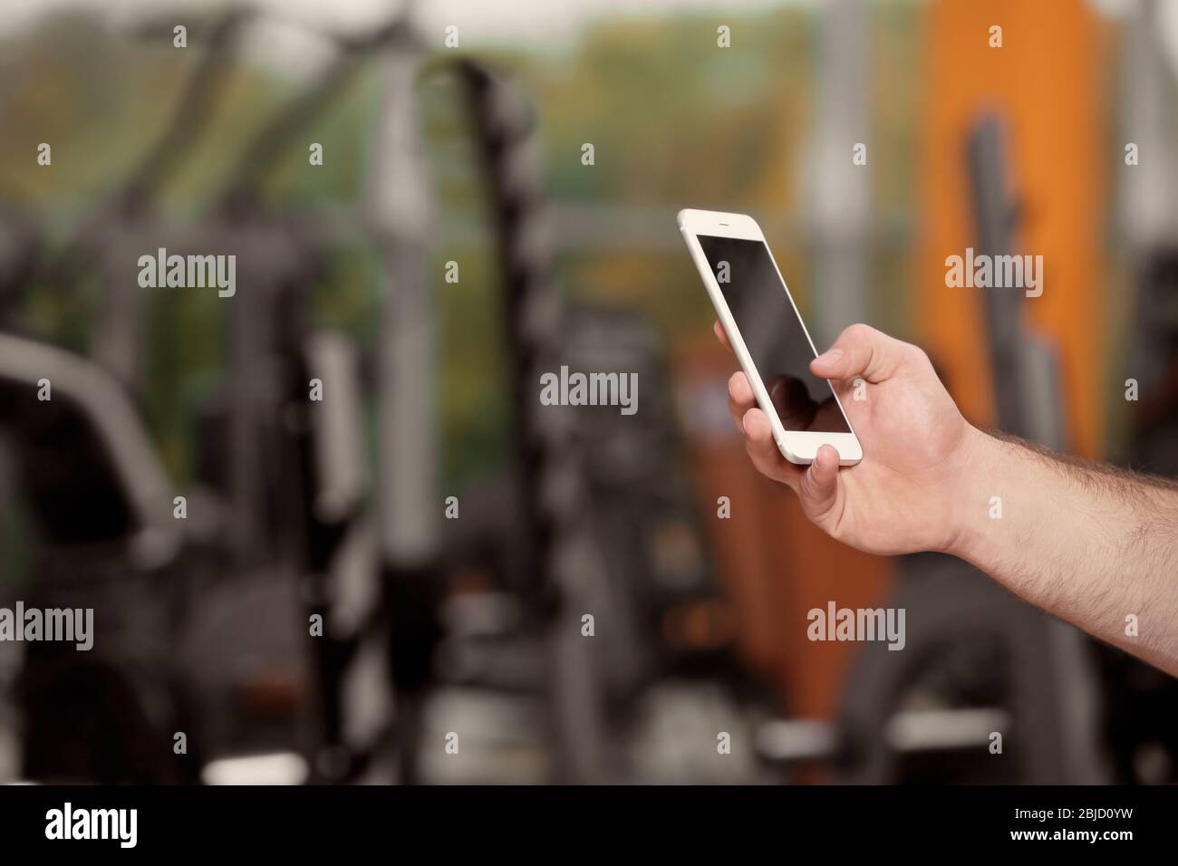 Male hand with modern phone in gym Stock Photo - Alamy