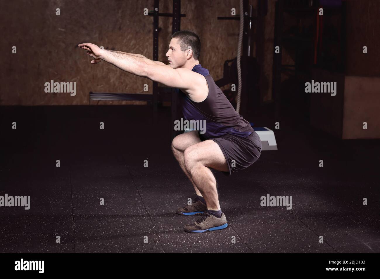 Young handsome man doing squats in gym Stock Photo - Alamy