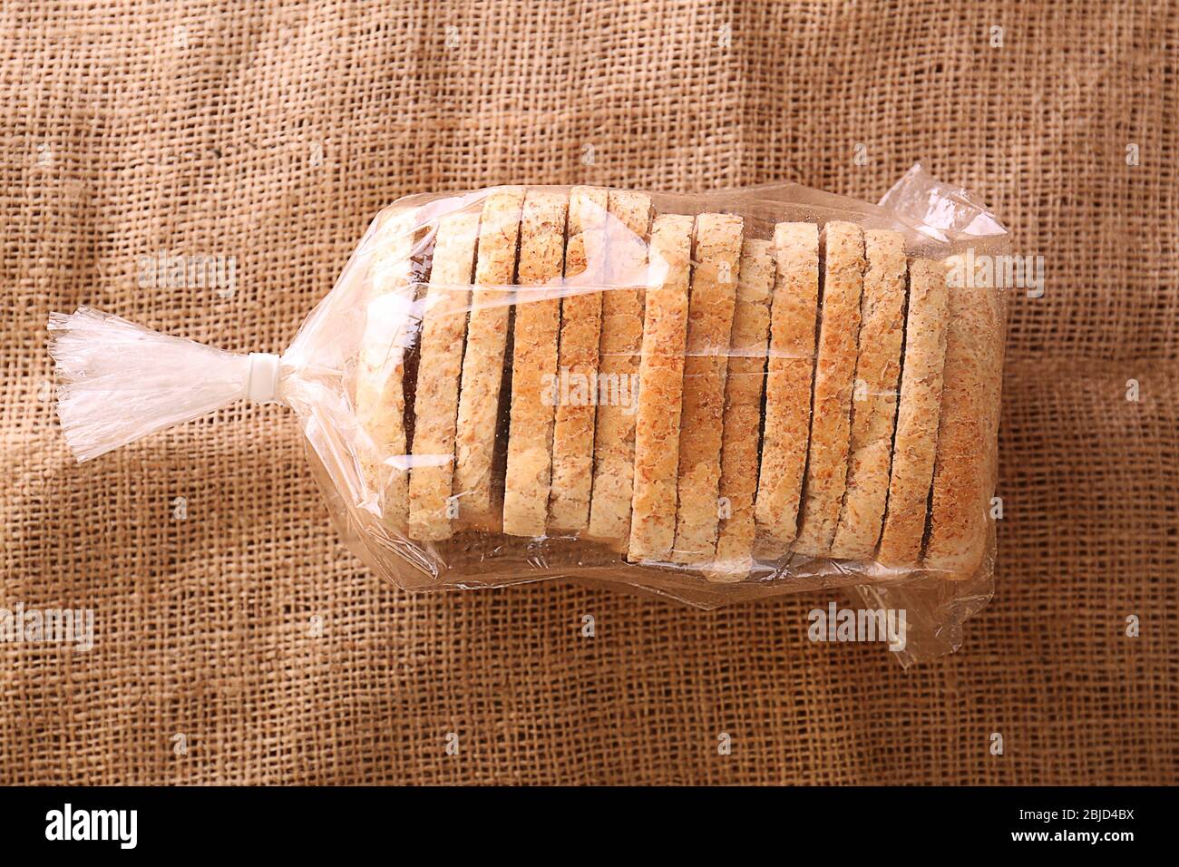 Sliced bread in plastic bag on sackcloth, top view Stock Photo - Alamy