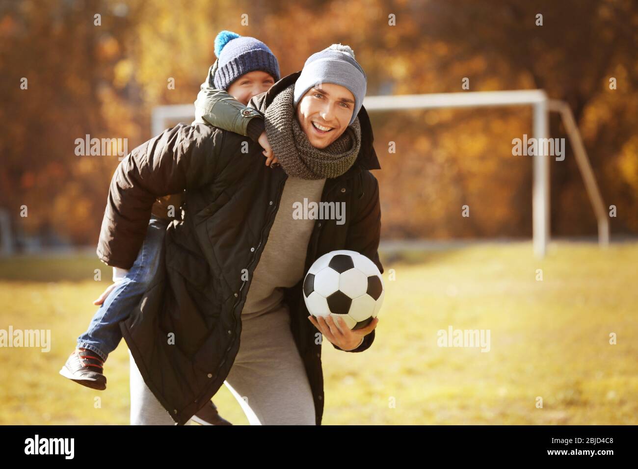 Father and son with ball on soccer pitch Stock Photo - Alamy