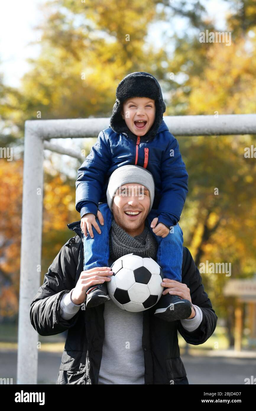 Father and son with ball on soccer pitch Stock Photo - Alamy