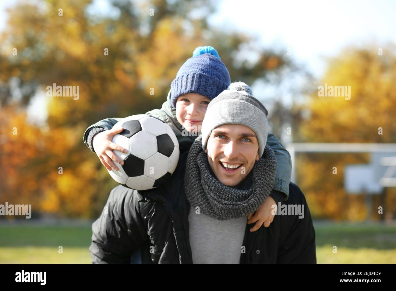 Father and son with ball on soccer pitch Stock Photo - Alamy