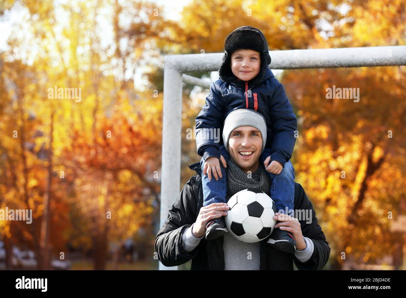 Father and son with ball on soccer pitch Stock Photo - Alamy