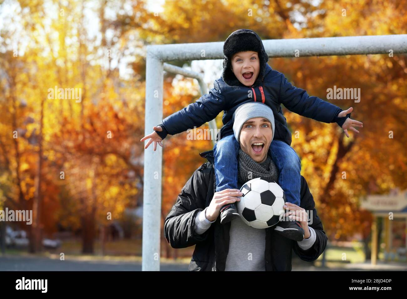 Father and son with ball on soccer pitch Stock Photo - Alamy