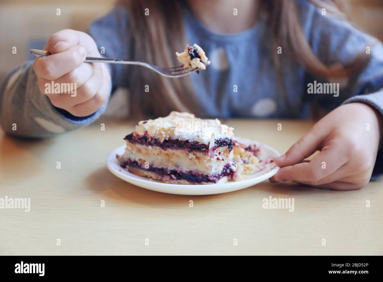 Little girl eating tasty cake, close up view Stock Photo - Alamy