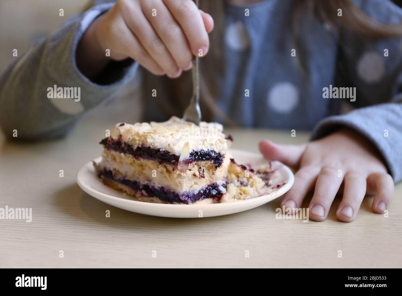 Little girl eating tasty cake, close up view Stock Photo - Alamy