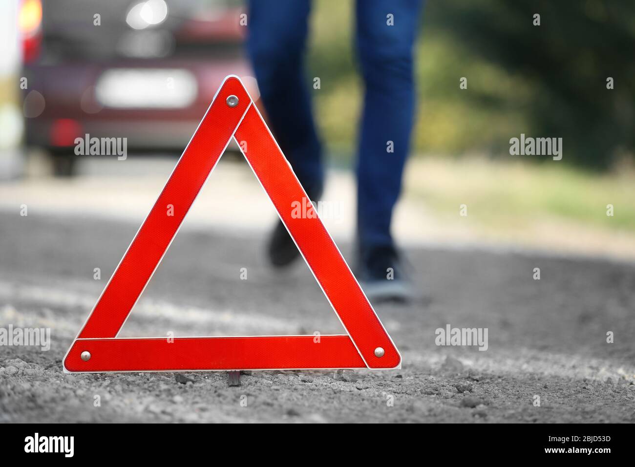 Close up view of red warning triangle on asphalt road. Emergency stop ...