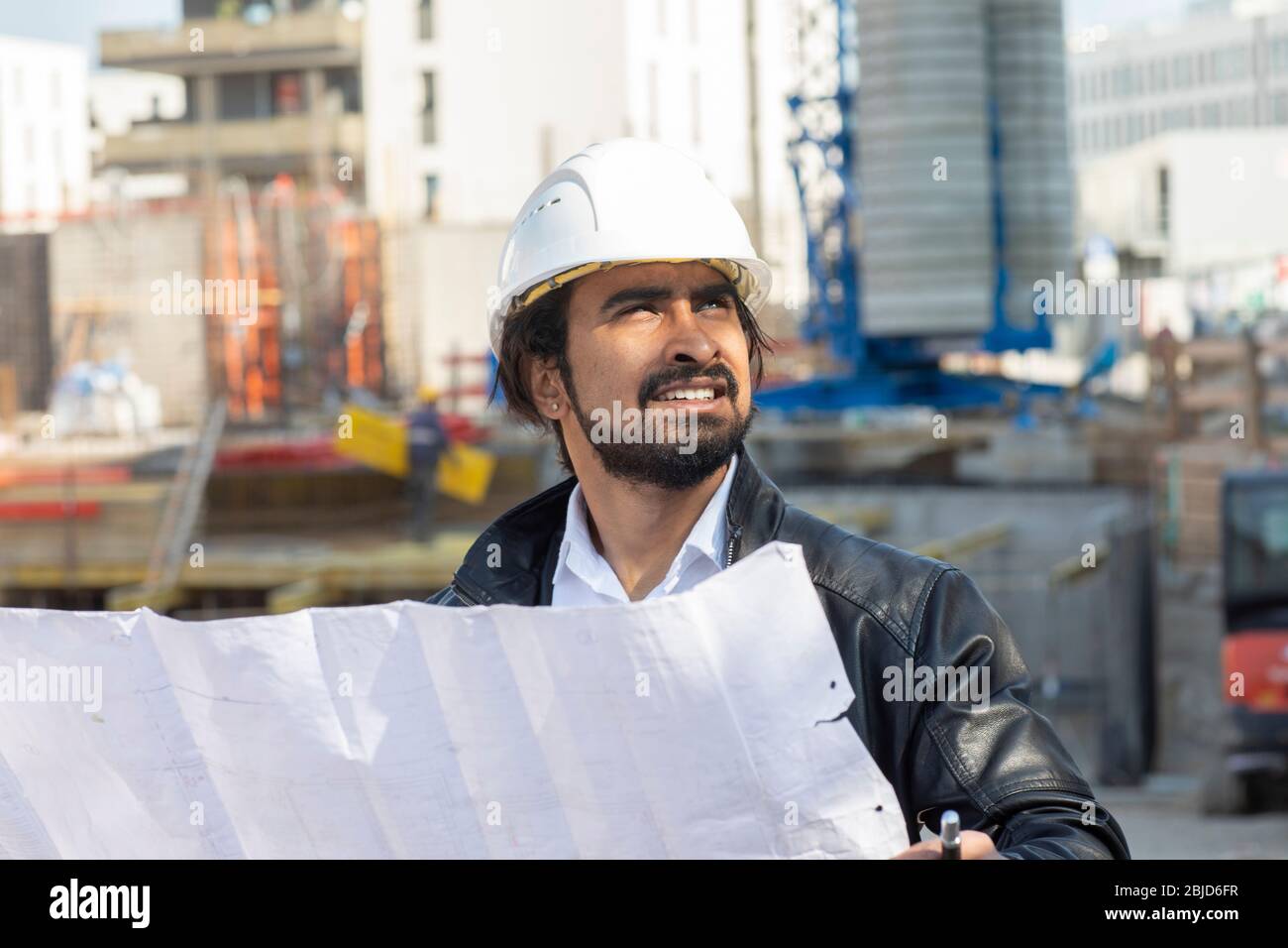 civil engineer working outside with helmet and plan Stock Photo - Alamy