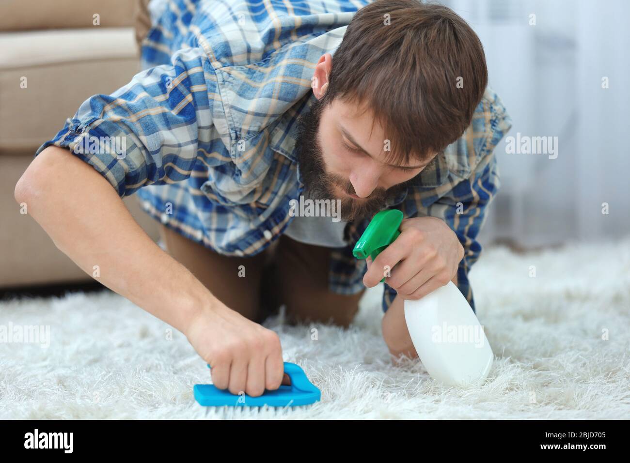 Funny young man cleaning carpet at home Stock Photo - Alamy