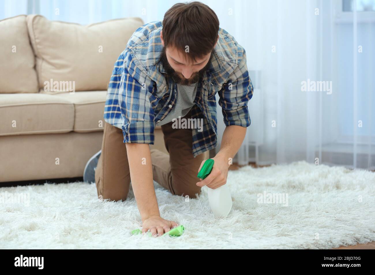 Funny young man cleaning carpet at home Stock Photo - Alamy